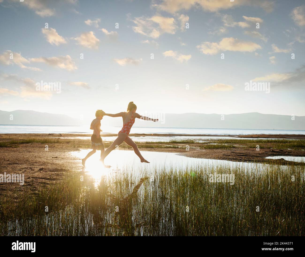 Two girls jumping into the lake hi-res stock photography and images - Alamy