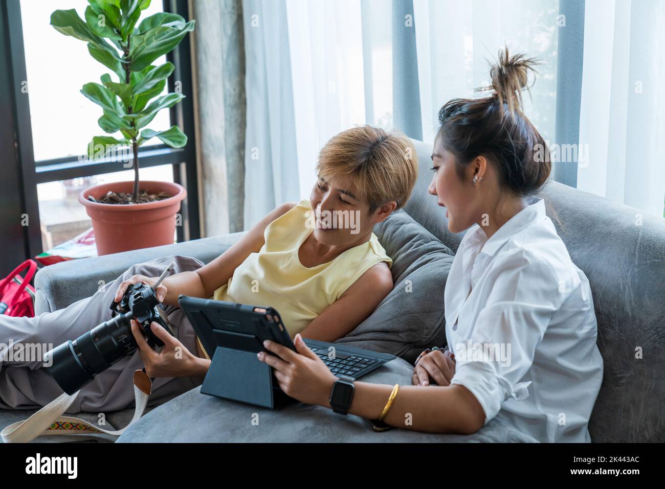 Grandma and grandson play the tablets on the sofa. Exchange knowledge ...