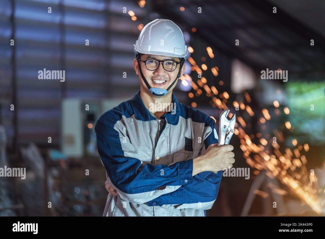 Asian technician smiling young male plumber with pipe wrench standing ...