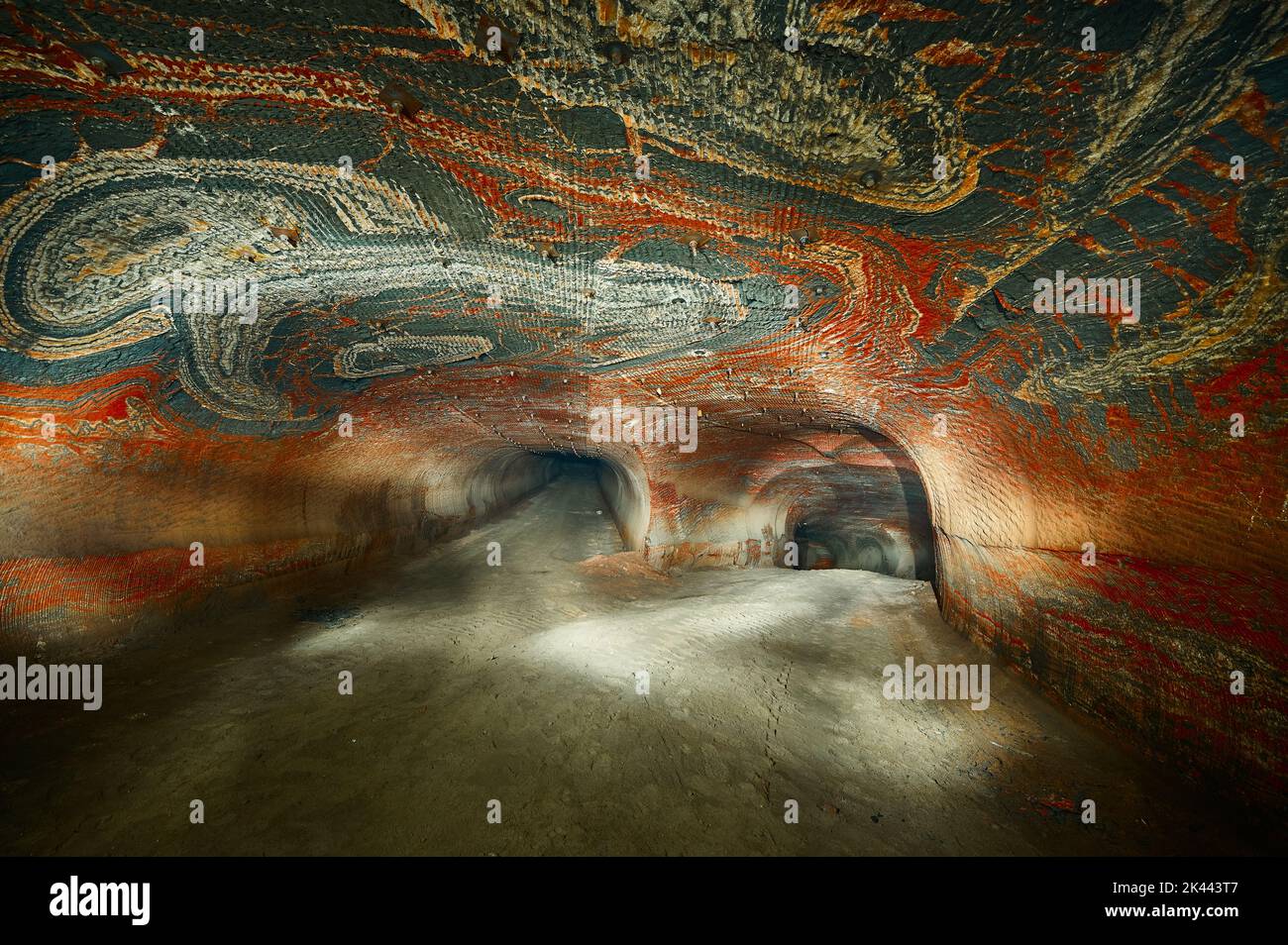 Outgoing tunnel of salt quarry with red patterns on walls Stock Photo ...