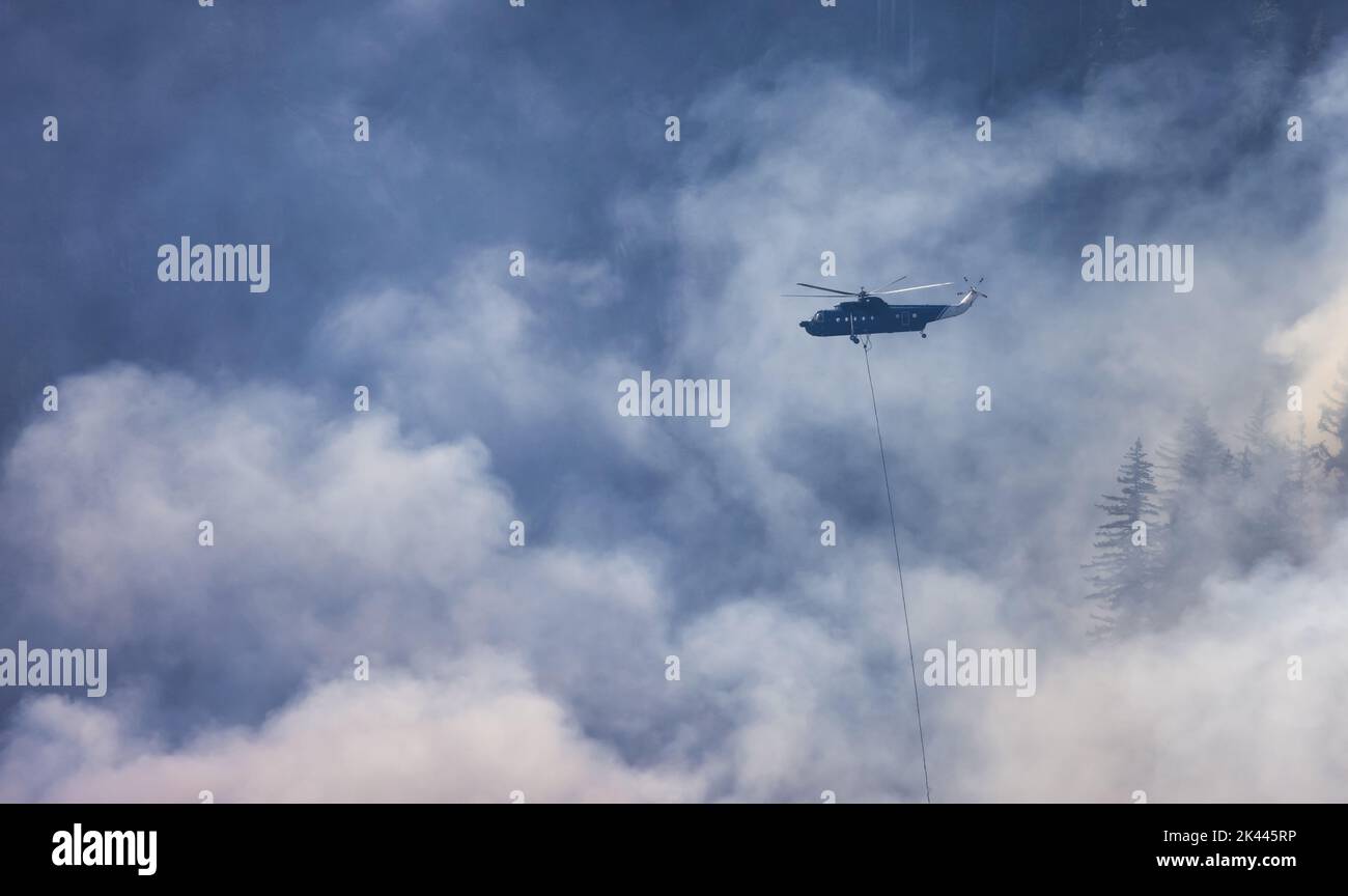 Wildfire Service Helicopter flying over BC Forest Fire and Smoke on the ...