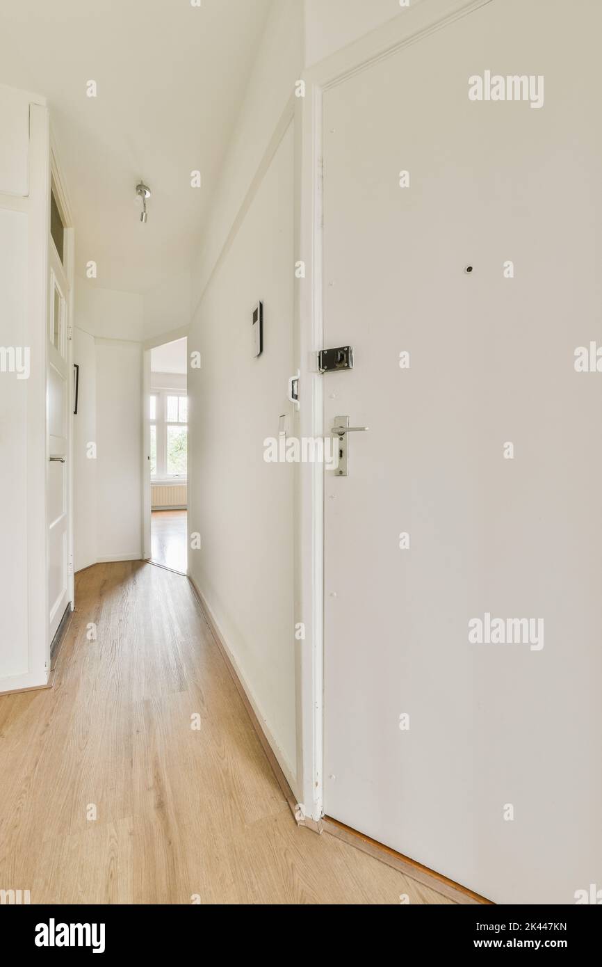 Light narrow hallway with many doors and parquet floor Stock Photo - Alamy