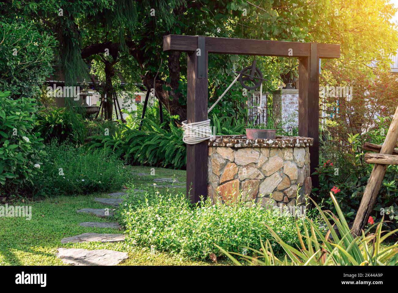 Beautiful artesian well made by stones and wheel pulley with metal ...