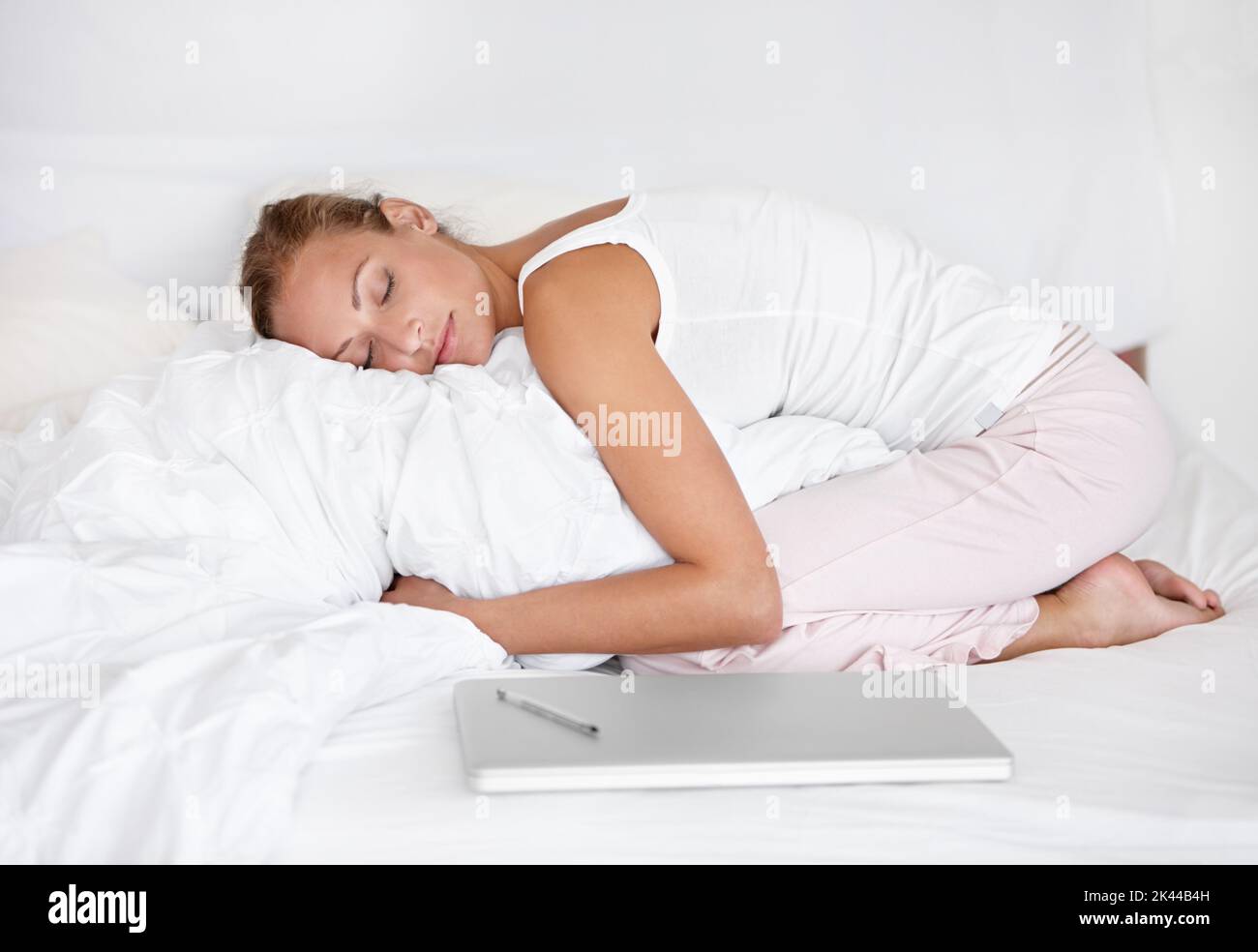 Lost in the comfort and softness. A beautiful young woman hugging her ...