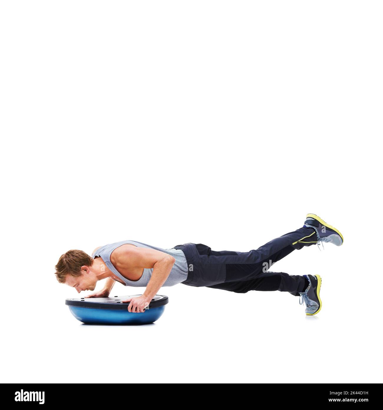 Hes working to acheive a muscular body. A handsome young man using a ...