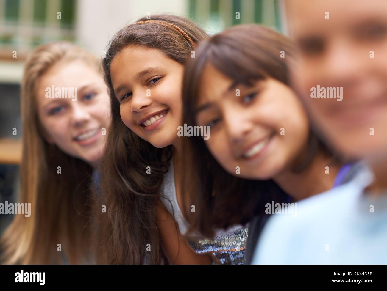 Friendship and smiles. Portrait of a young girl standing amongst her ...