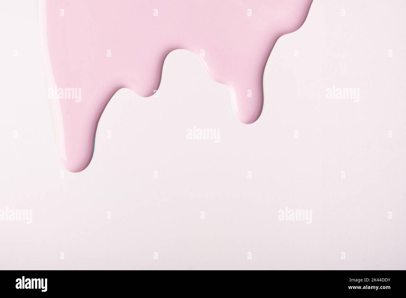 Light pink liquid drops of paint color flow down on isolated white ...