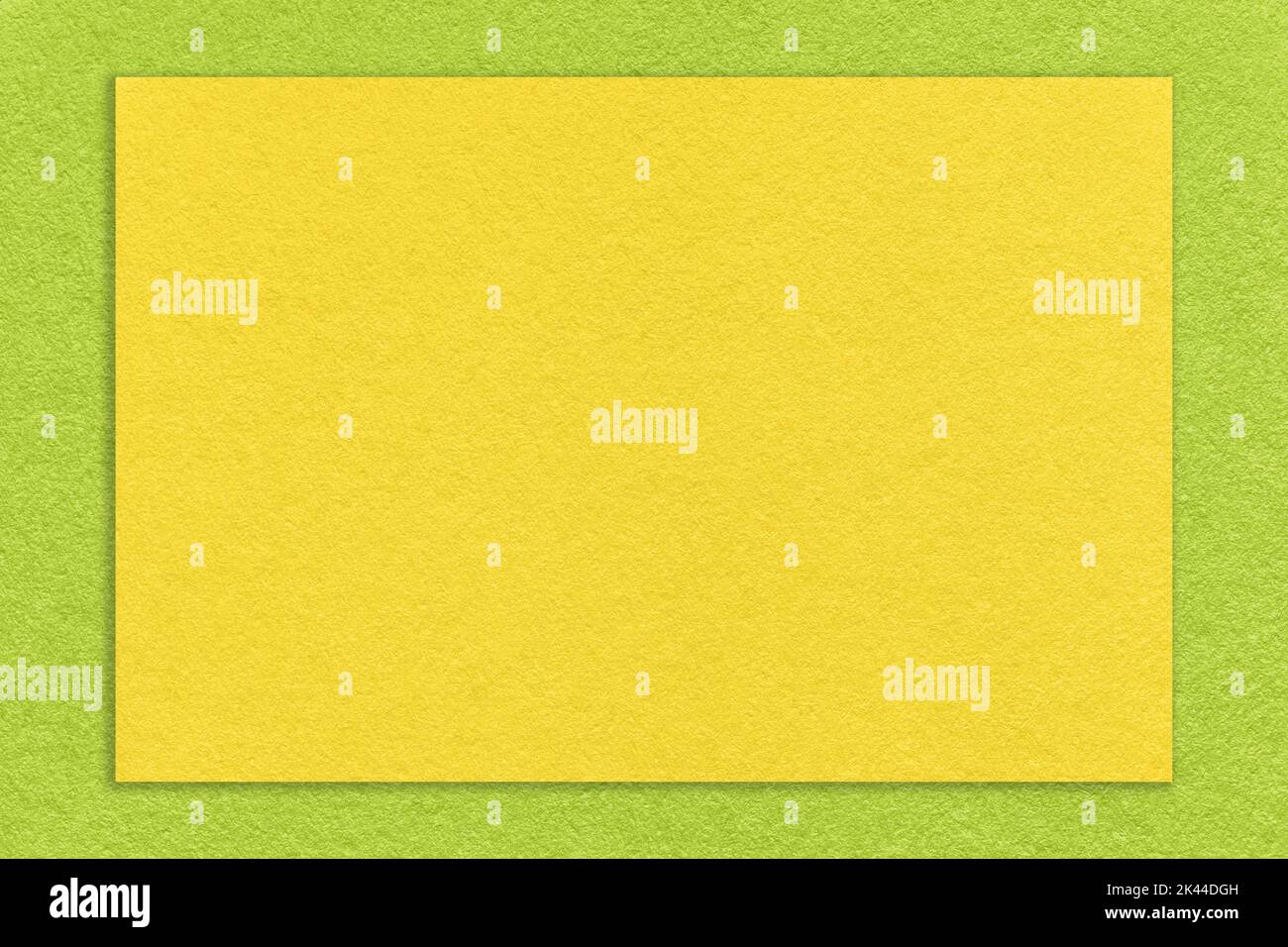 Texture of craft yellow paper background with green border, macro ...