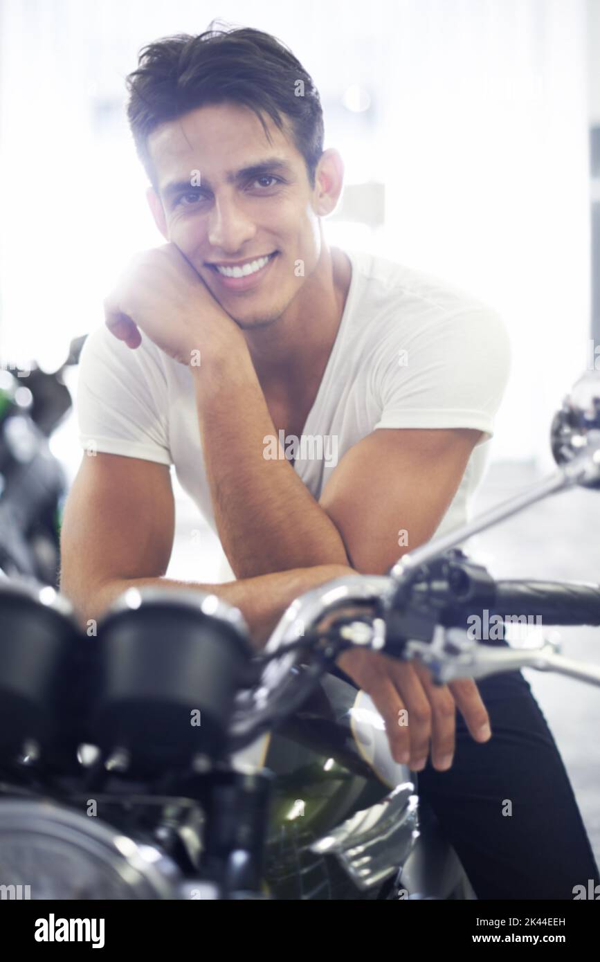 Hes got the biker look down. A handsome young man sitting on his ...