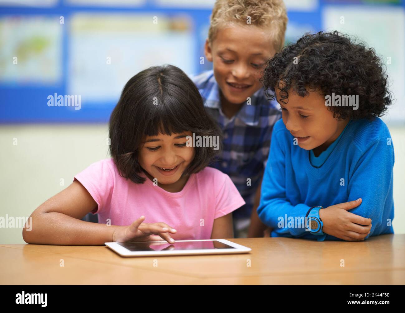 Learning using tablet technology. Portrait of three school students ...