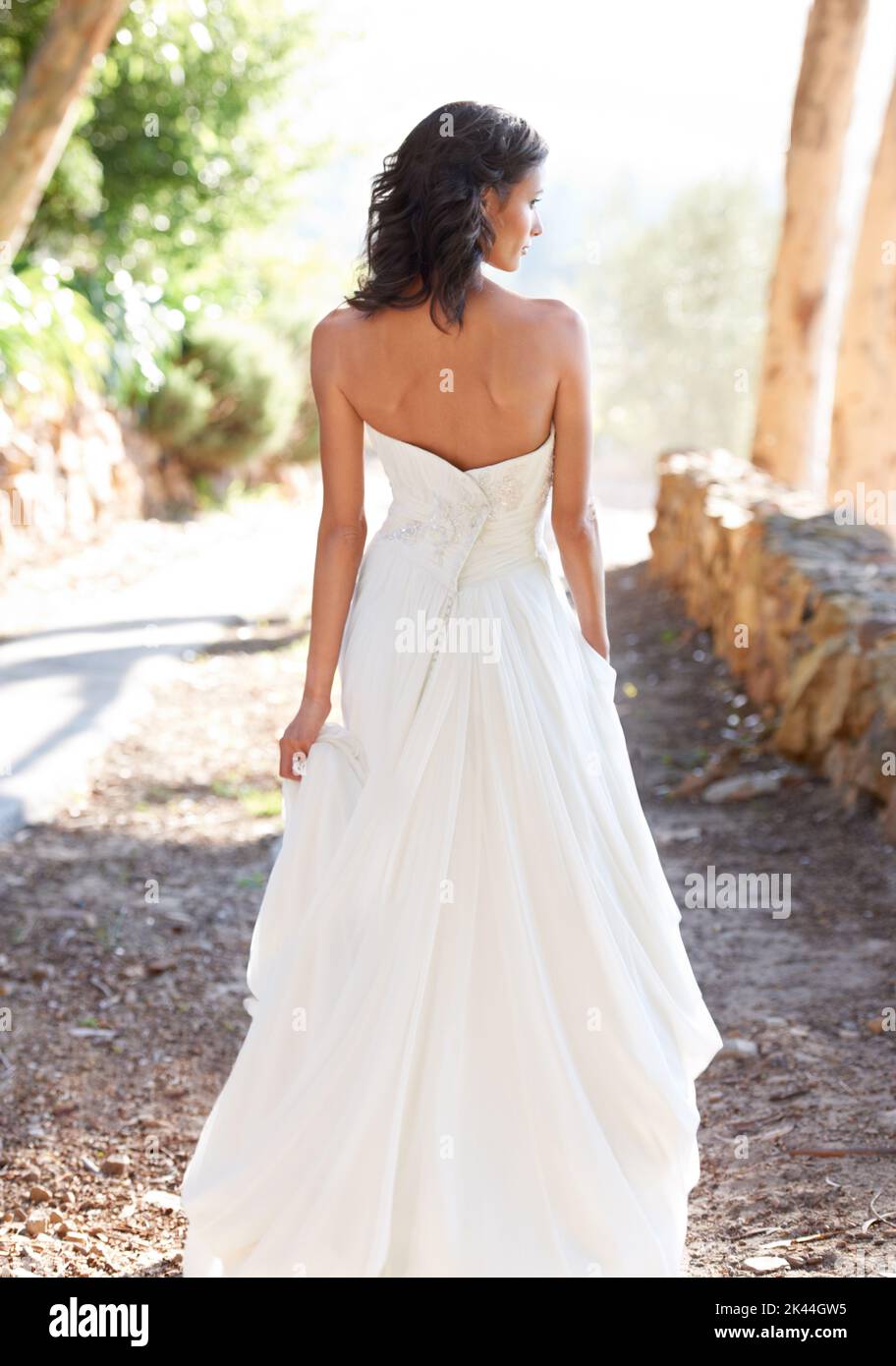 On the way to her love. A young bride looking to the side while walking ...