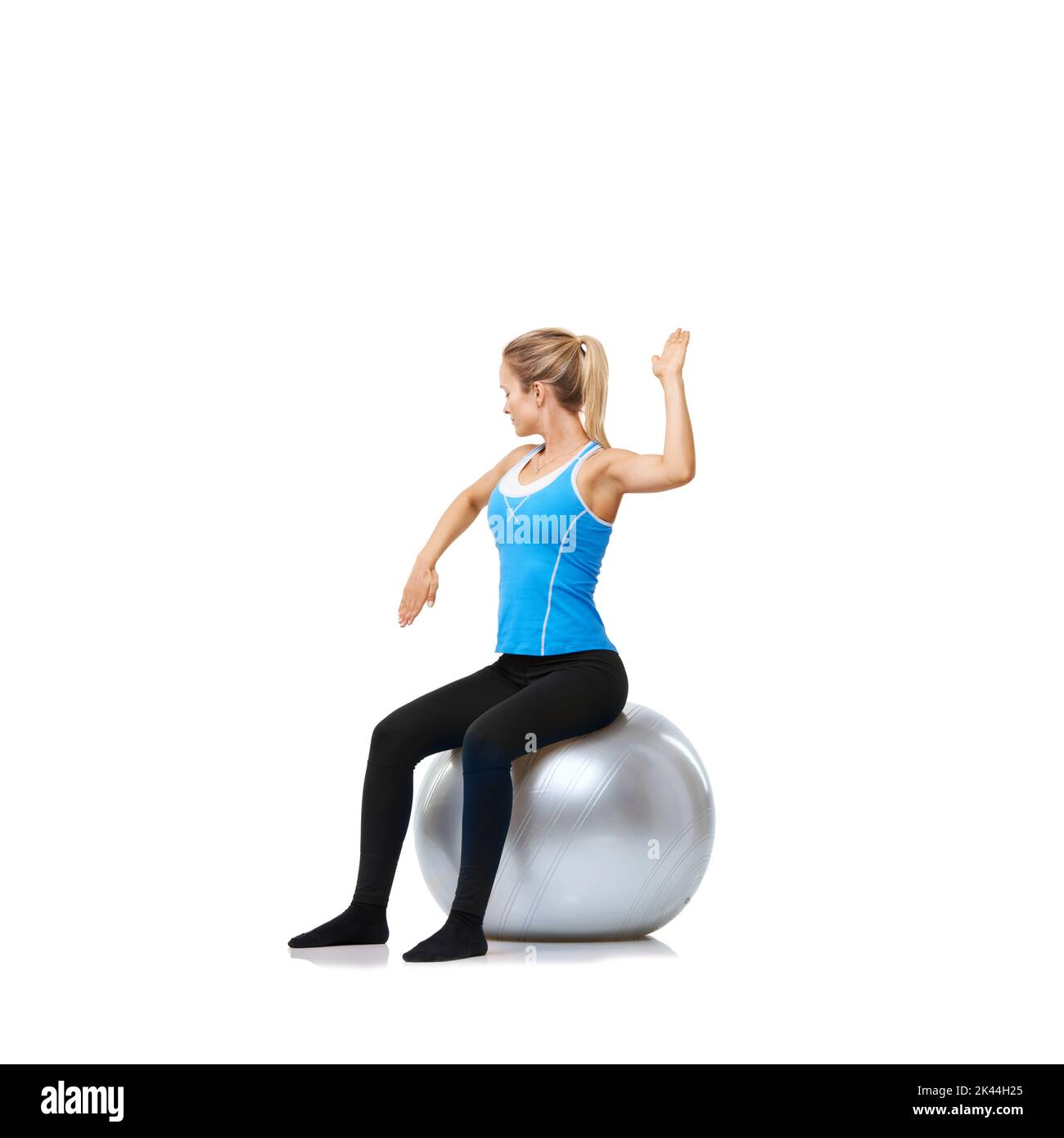 Toning up for Summer. a woman sitting on an exercise ball while toning ...