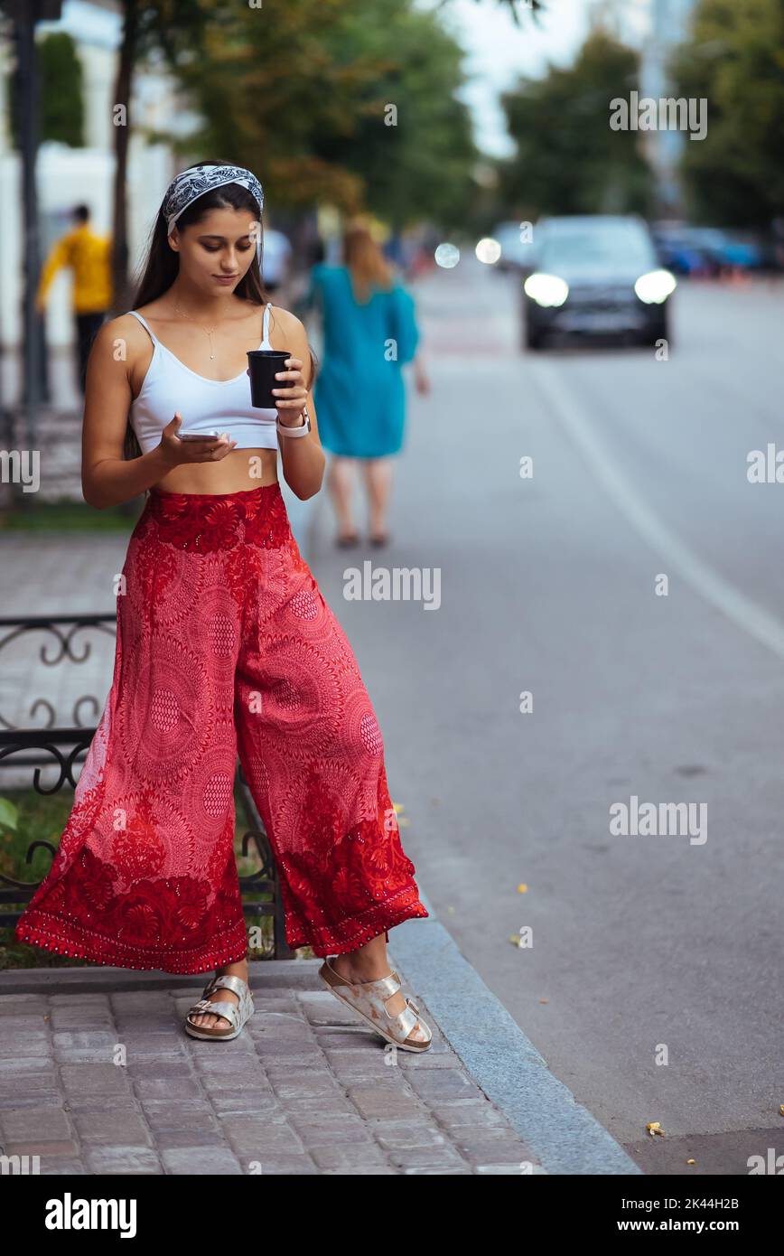 Woman in the street drinking morning coffee and use smartphone Stock ...