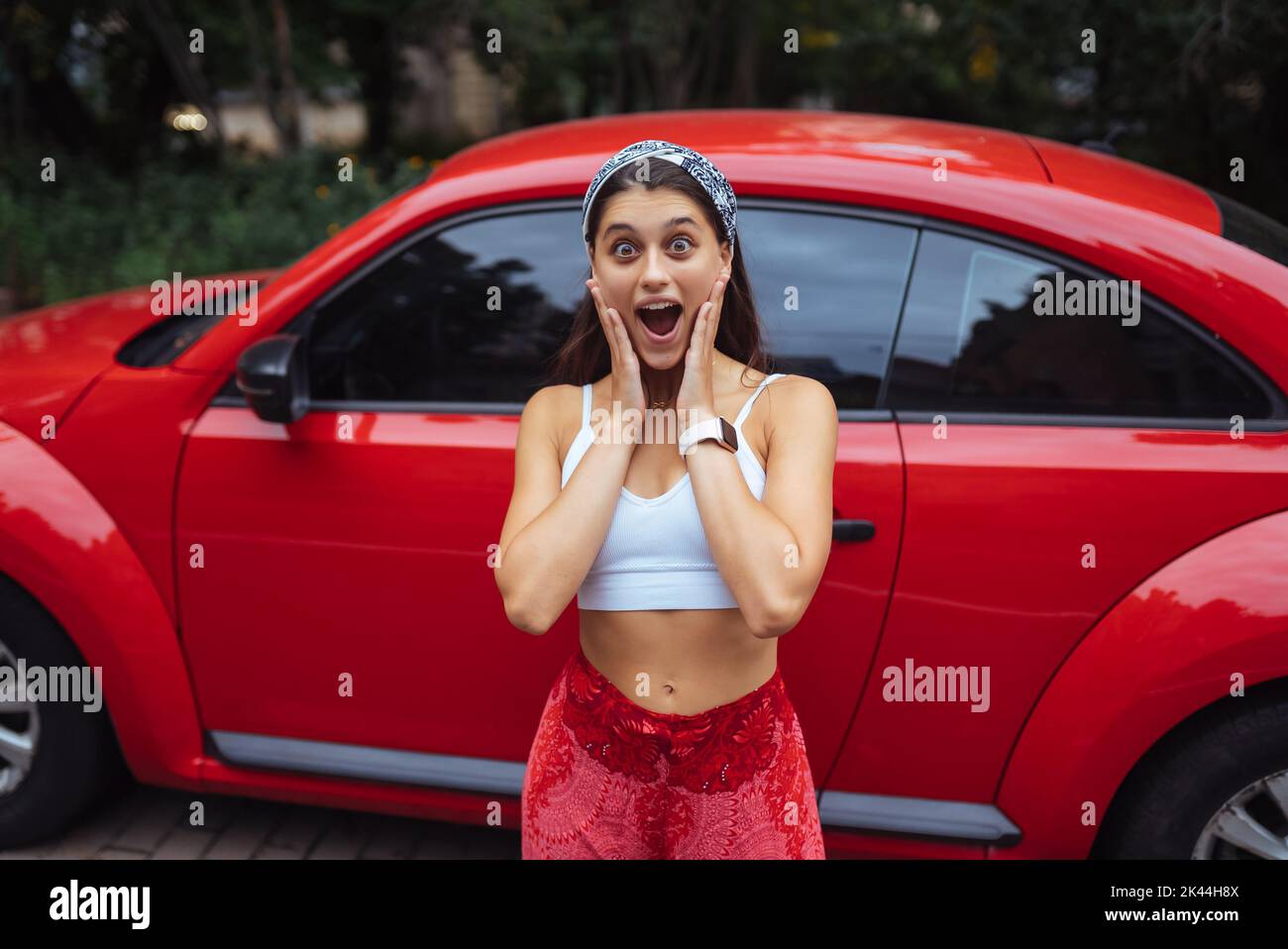 Portrait of pretty Caucasian woman standing against new red car Stock ...