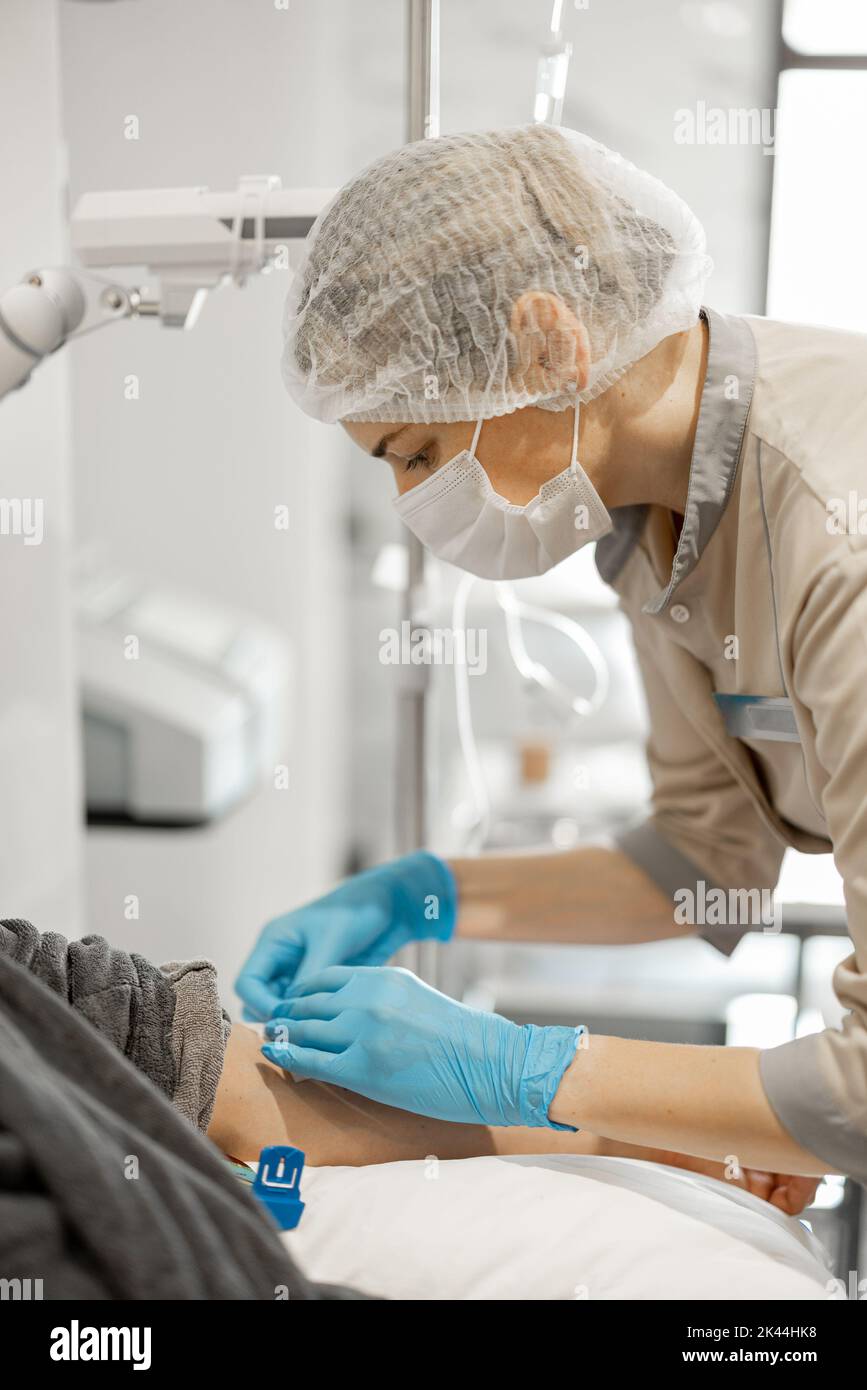 Woman with nurse during blood washing procedure at medical centre Stock ...