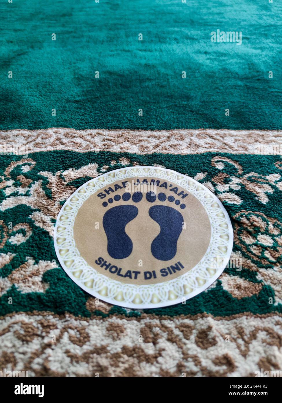 Close up of sign on green carpet for prayer spot with flower pattern in ...