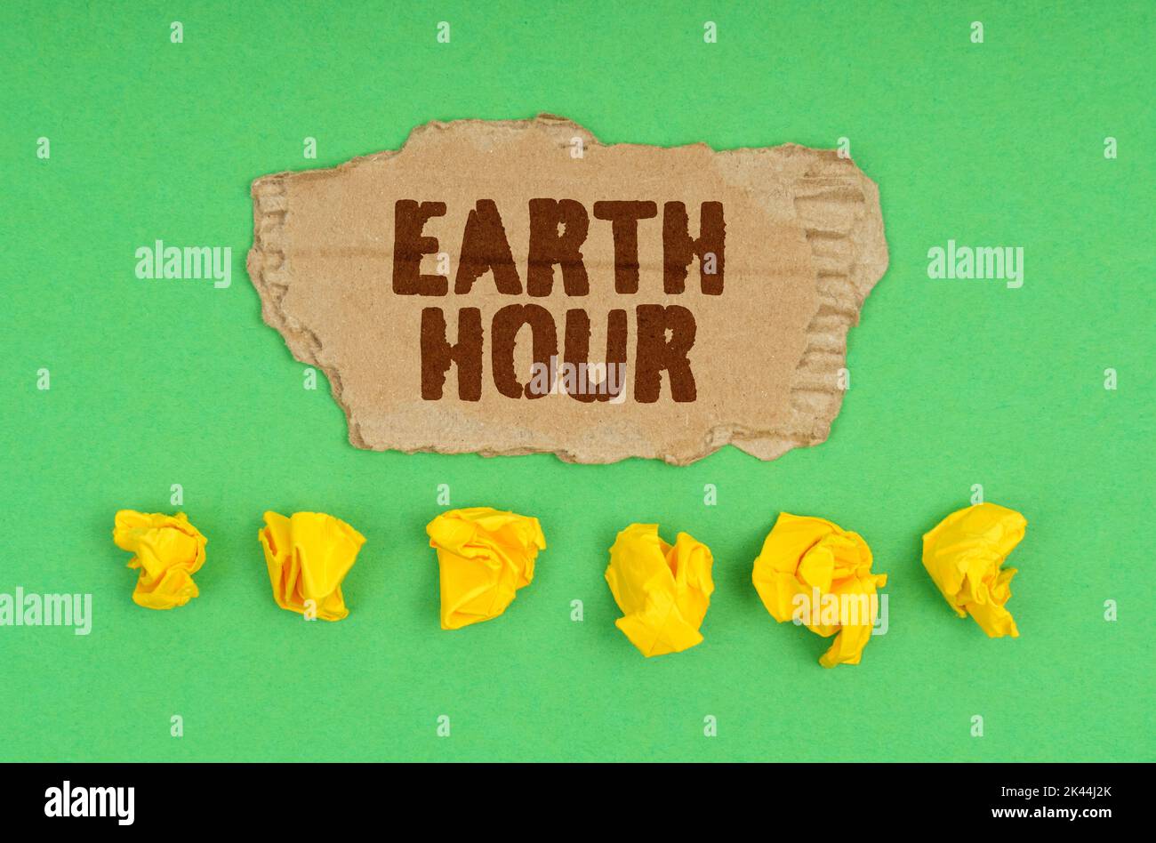 Ecology concept. On a green background, crumpled yellow paper and a ...