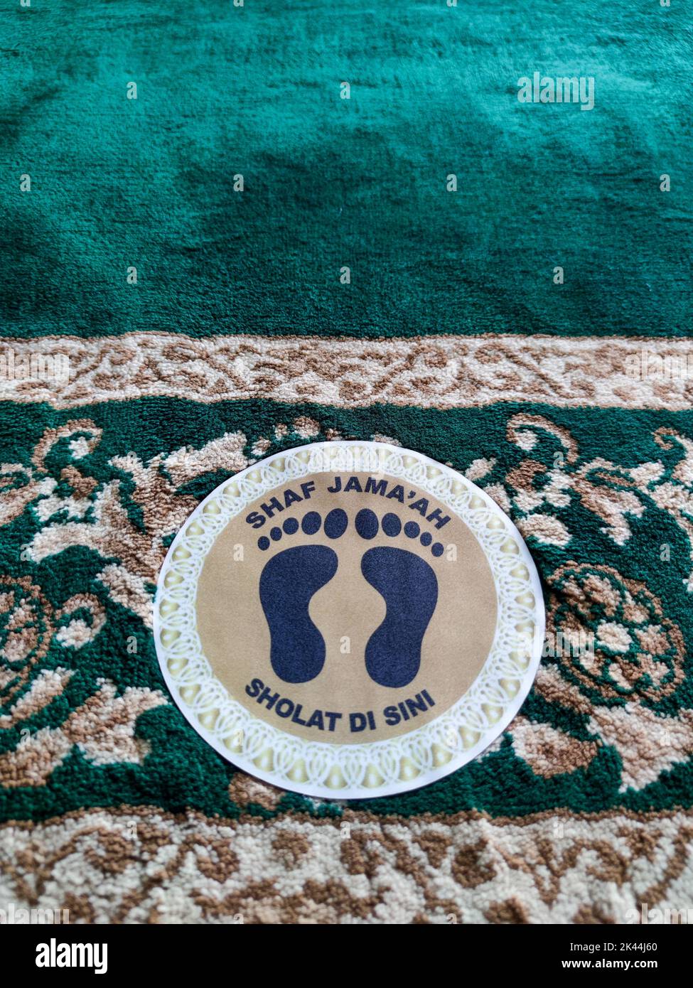 Close up of sign on green carpet for prayer spot with flower pattern in ...