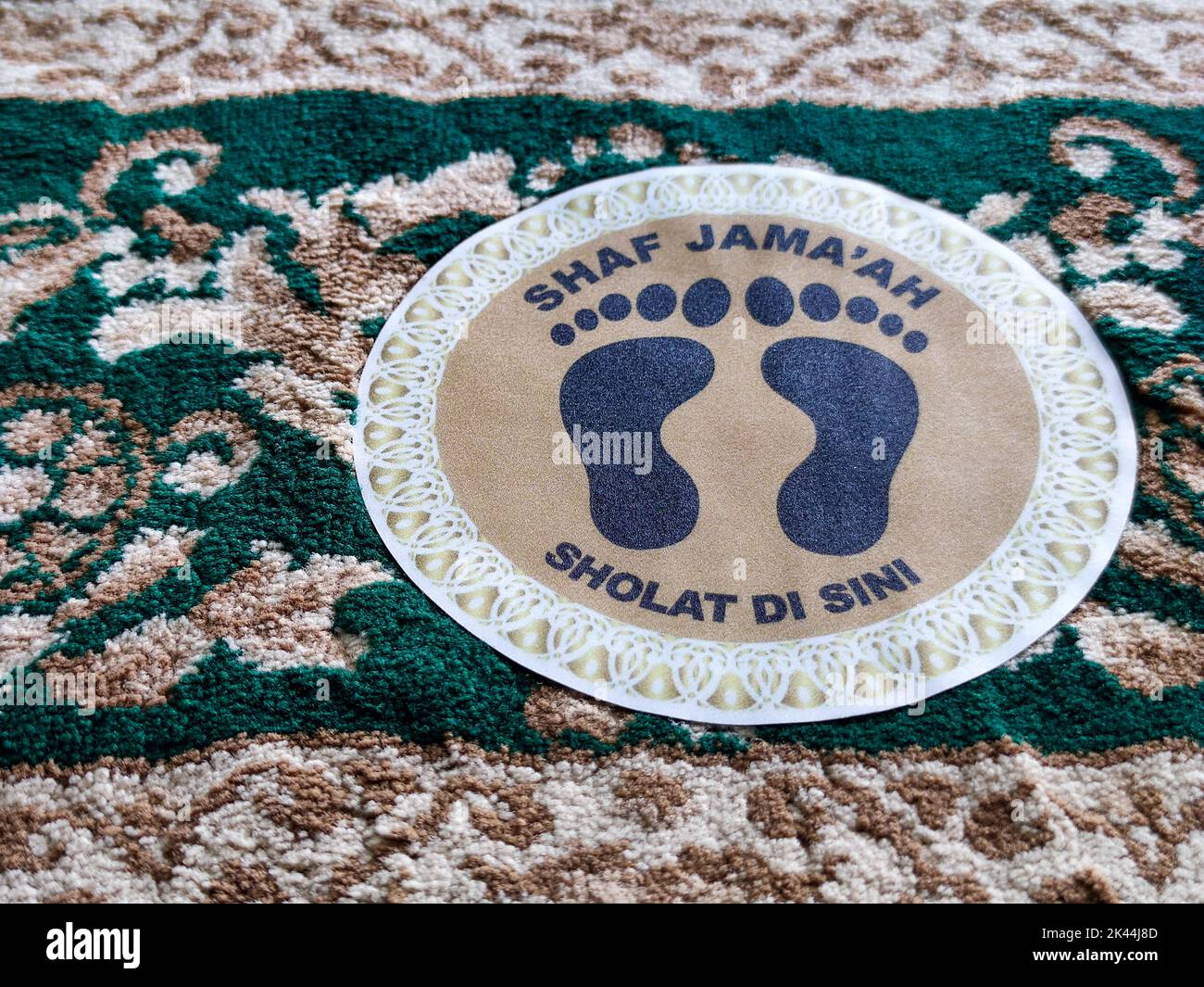 Close up of sign on green carpet for prayer spot with flower pattern in ...