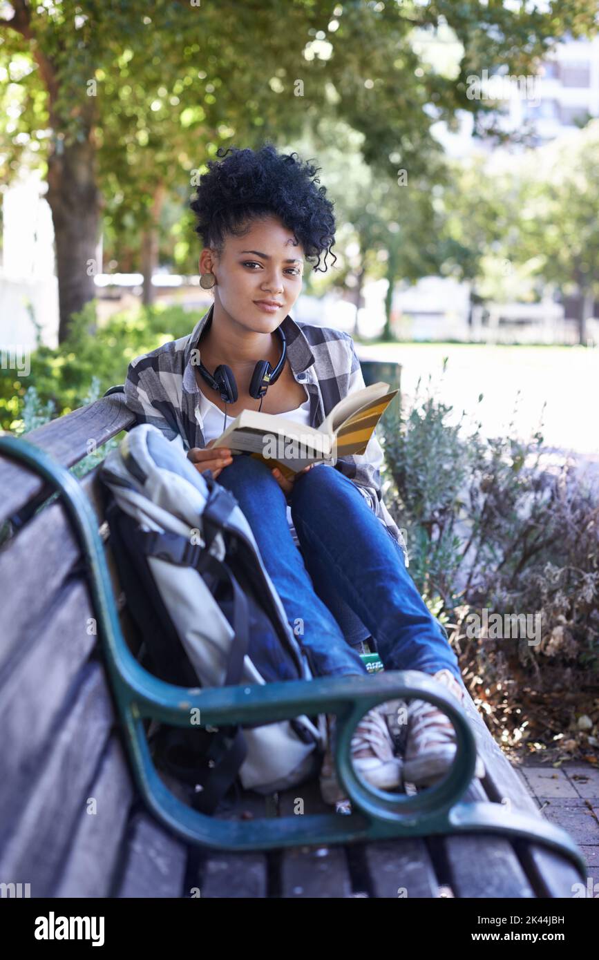 Relaxed and enjoying the outside air. A student sitting on a bench ...