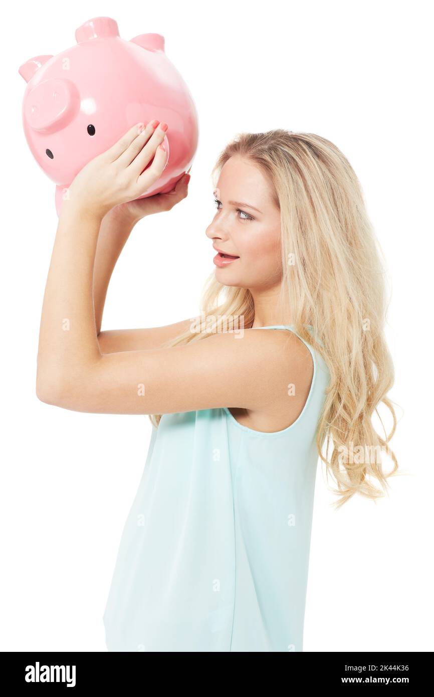 Im broke...A pretty young woman shaking her piggy bank and wondering ...