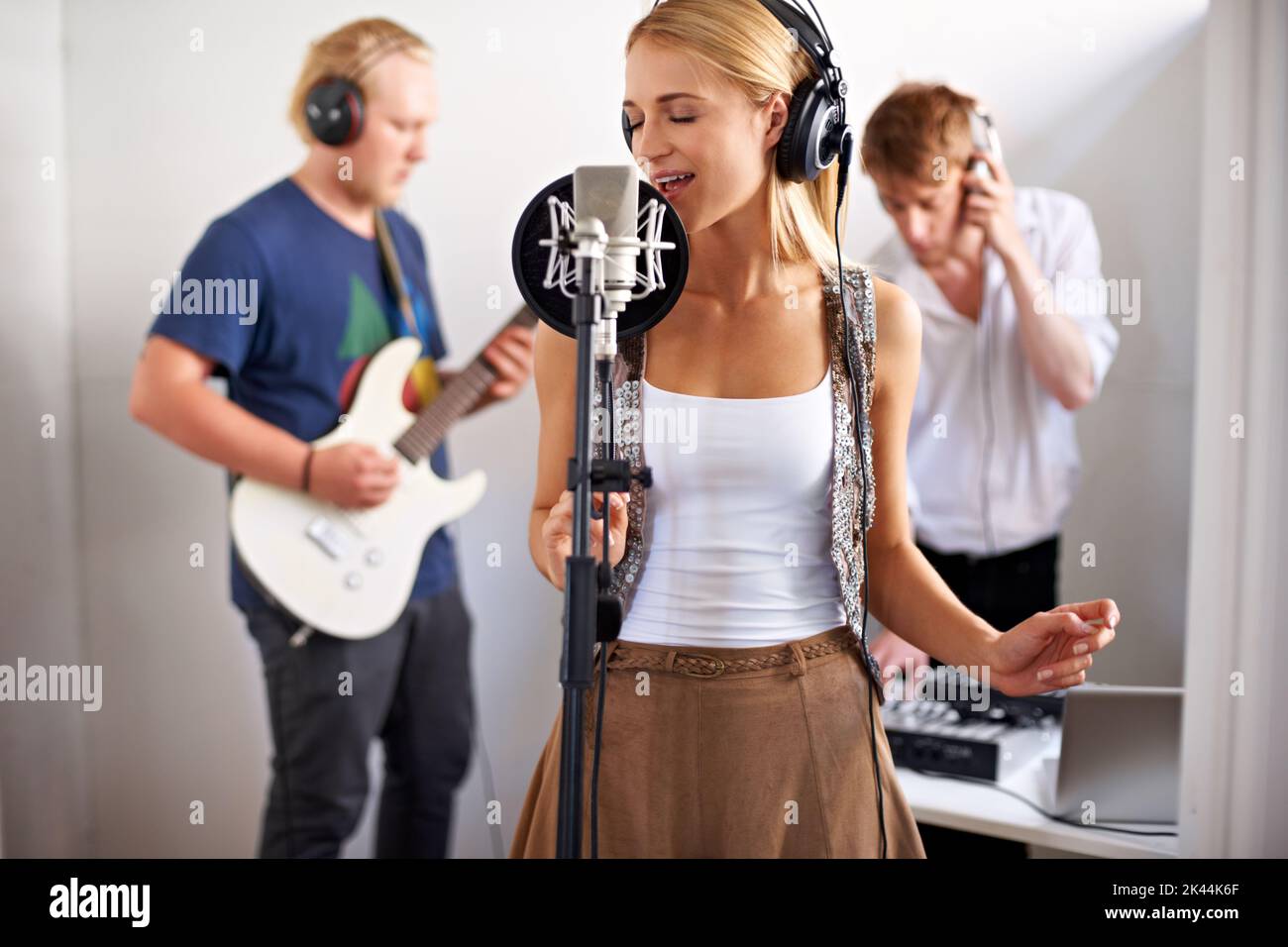 Making musical history. A band consisting of three young adults busy recording a track Stock ...