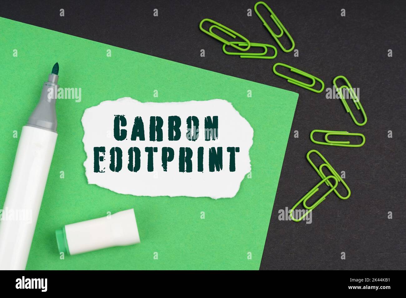 Ecology concept. On a black background, a marker, paper clips, a sheet ...