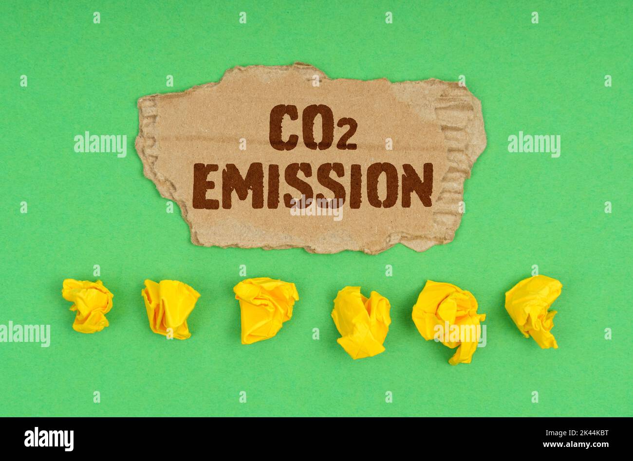Ecology concept. On a green background, crumpled yellow paper and a ...