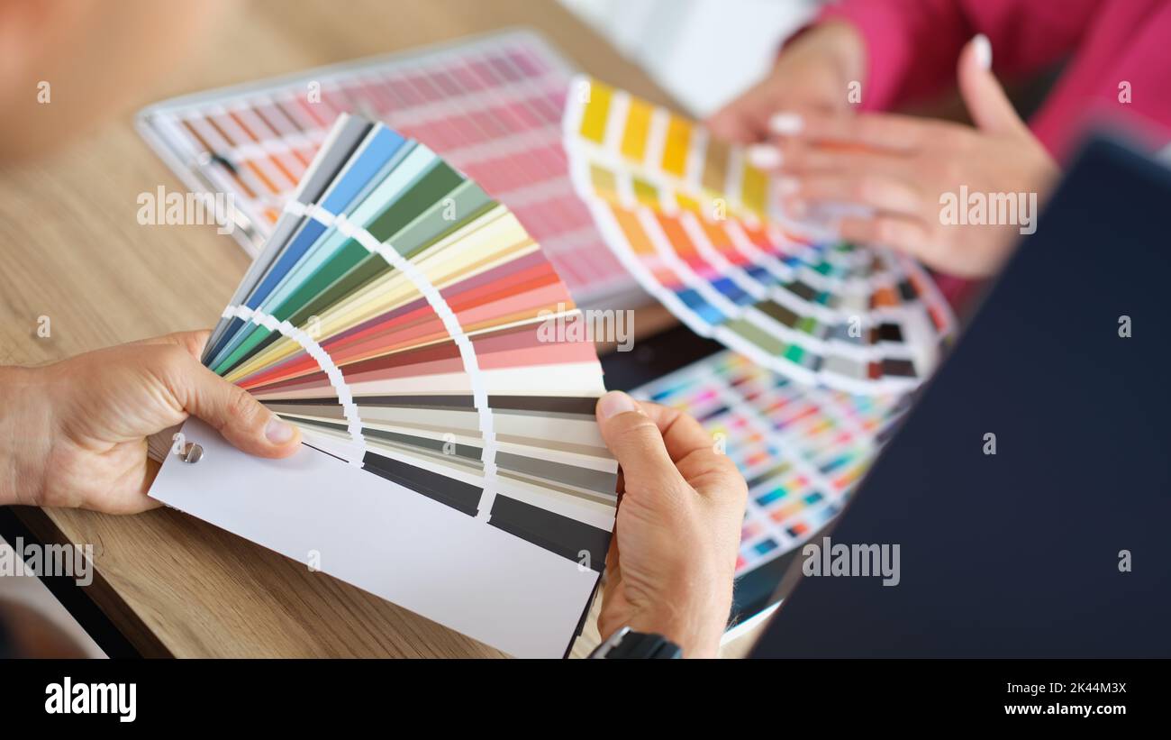 Creative designer advises client and shows color sample in color ...