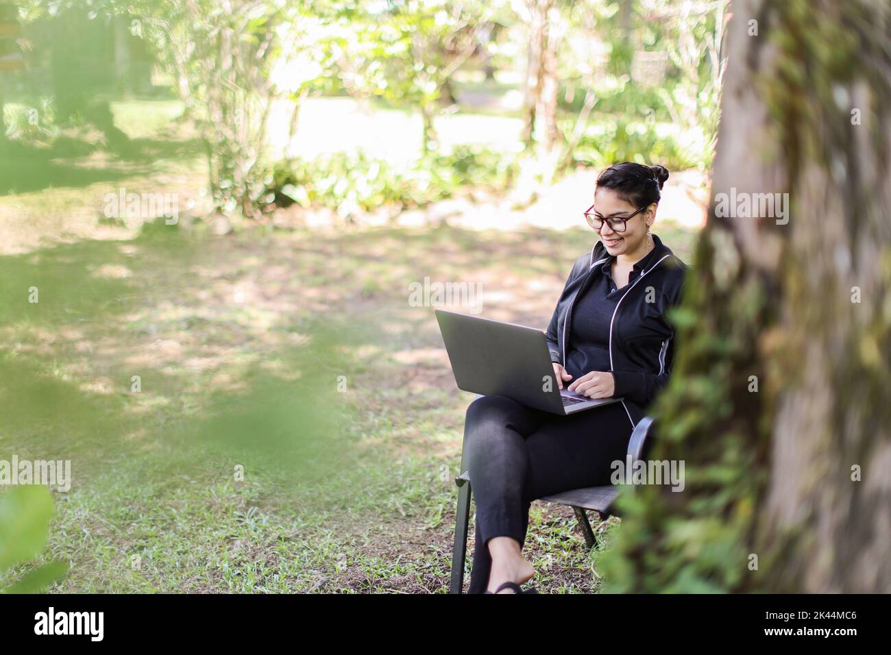 Latin American Woman Looking computer Smiling working with laptop in ...
