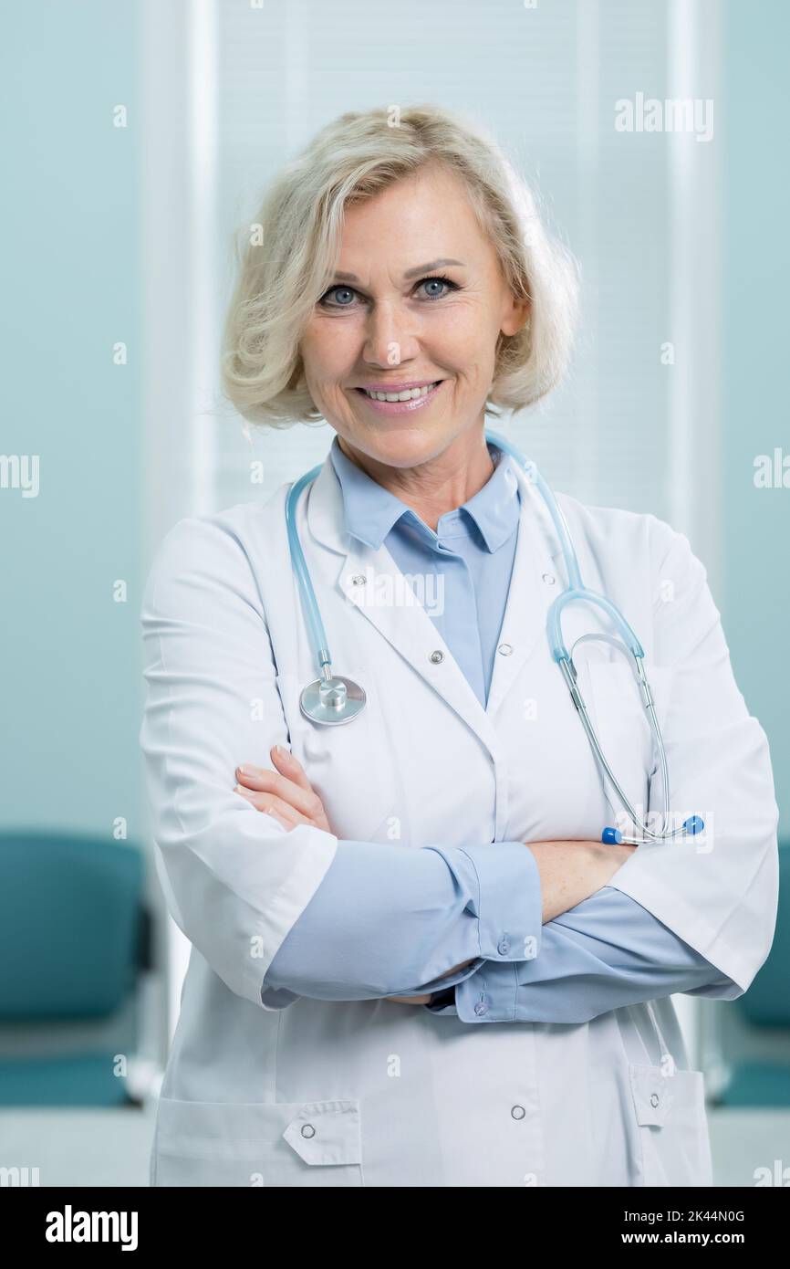 Portrait of confident female doctor in hospital ward crossing arms on ...