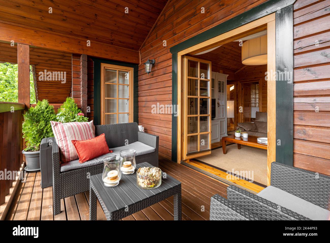 A wooden cottage with beautiful terrace and table with sofa. Cozy and ...