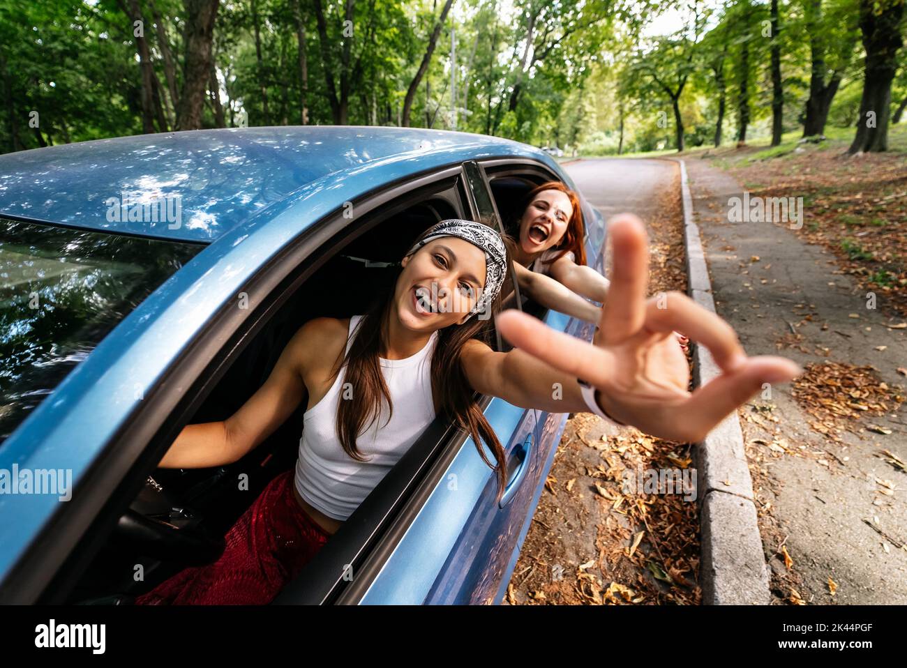 Two girlfriends fool around and laughing together in a car Stock Photo ...