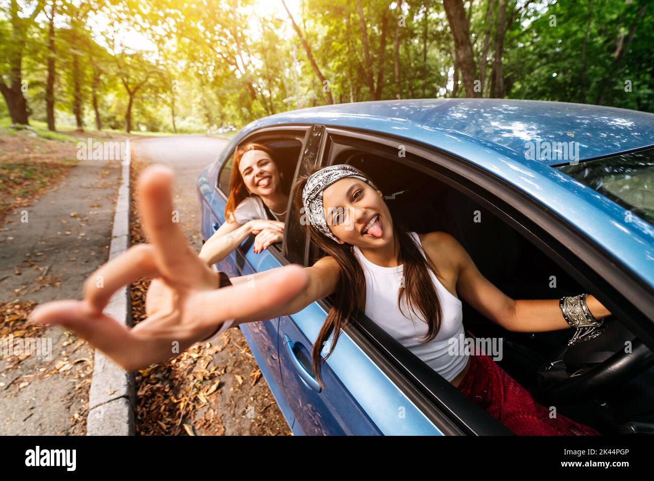 Two girlfriends fool around and laughing together in a car Stock Photo ...