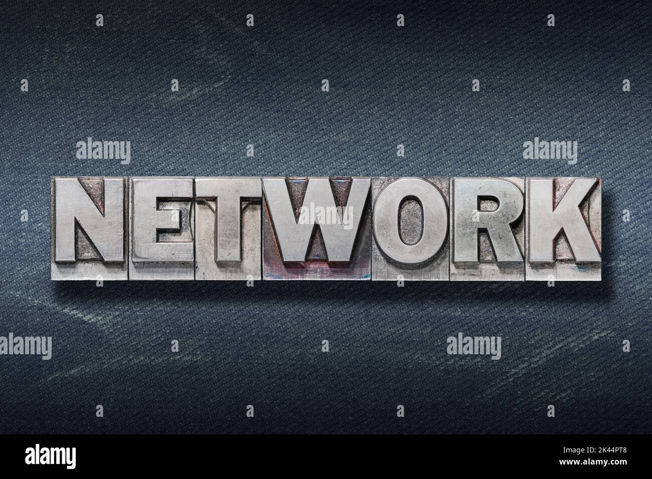 network word made from metallic letterpress on dark jeans background ...