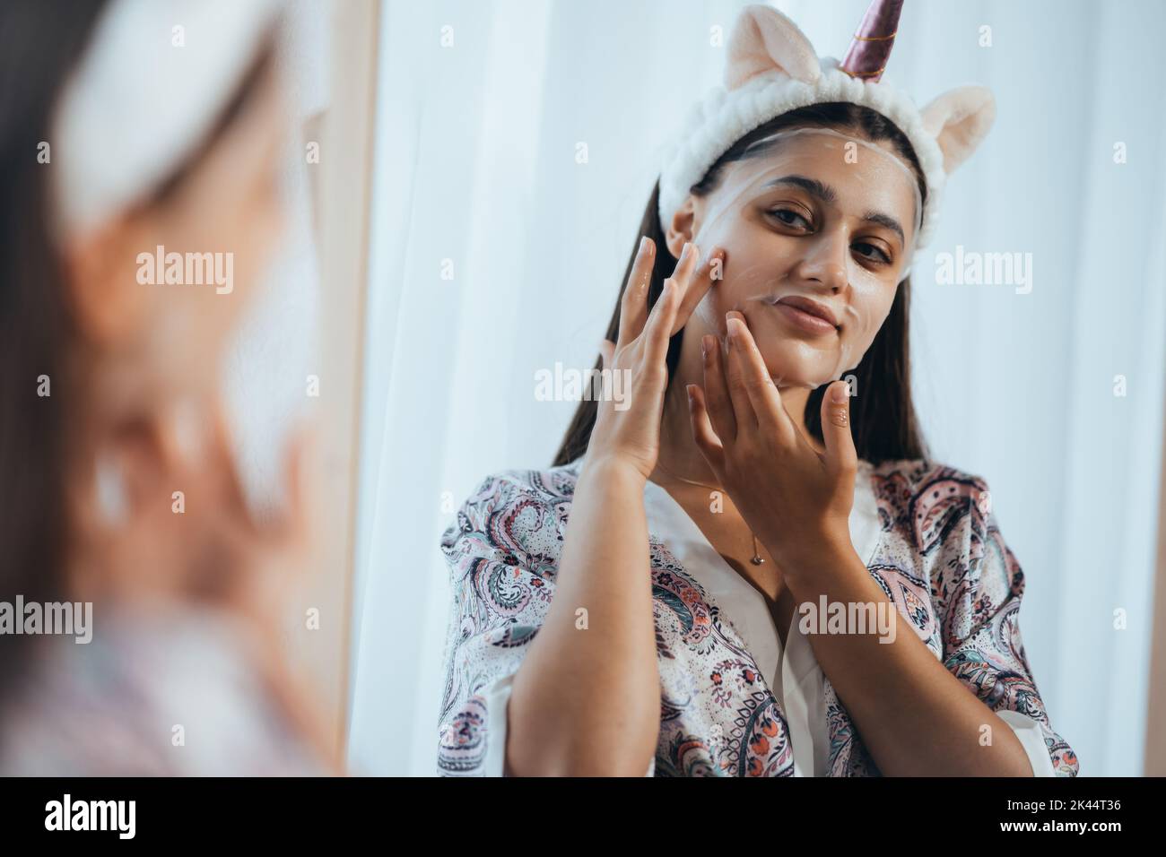 Beautiful model applying cosmetic cream treatment on her face Stock Photo - Alamy
