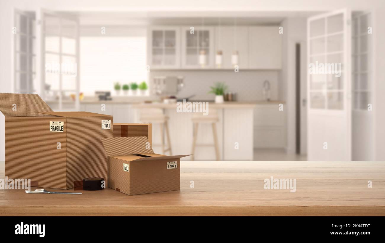 Wooden table, desk or shelf with stack of cardboard boxes over blurred ...