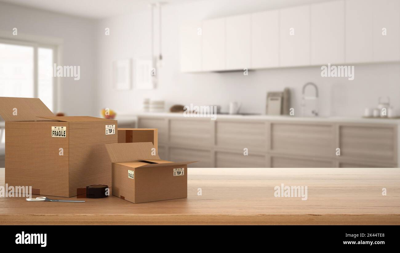 Wooden table, desk or shelf with stack of cardboard boxes over blurred ...
