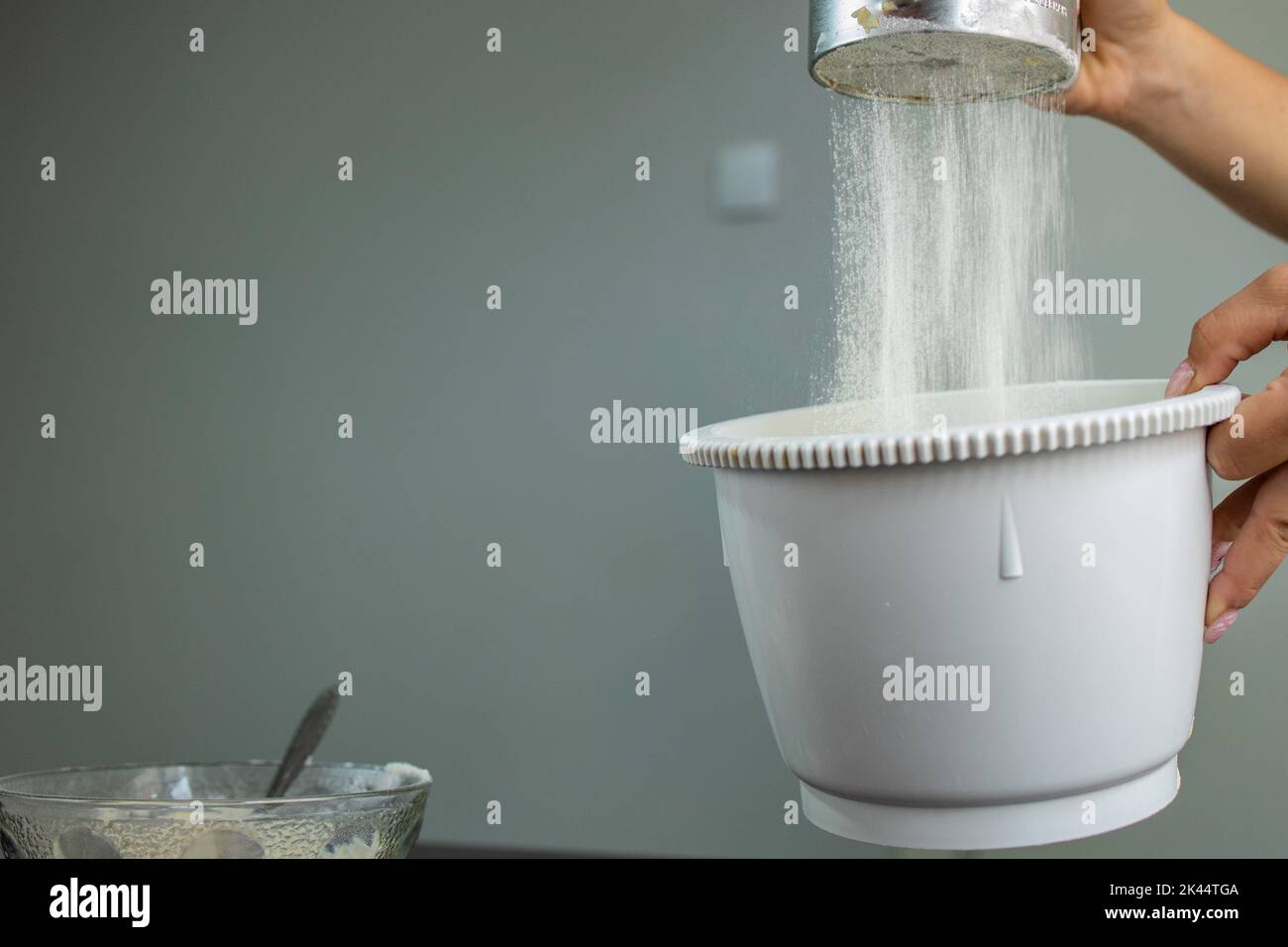 making cookies. sifting flour into a bowl. the flour expands and ...