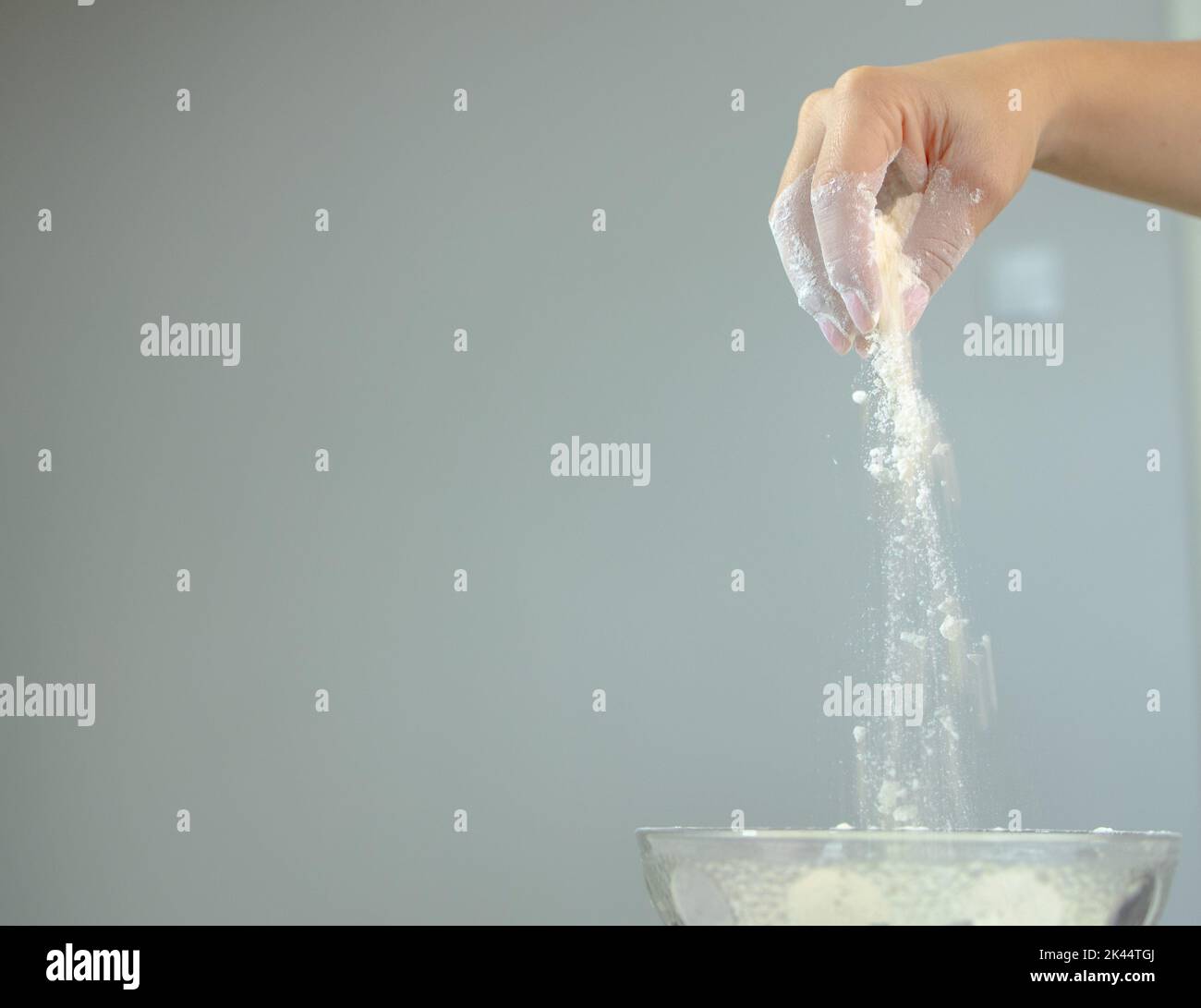 making cookies. pouring flour from the hand into a bowl. flour ...