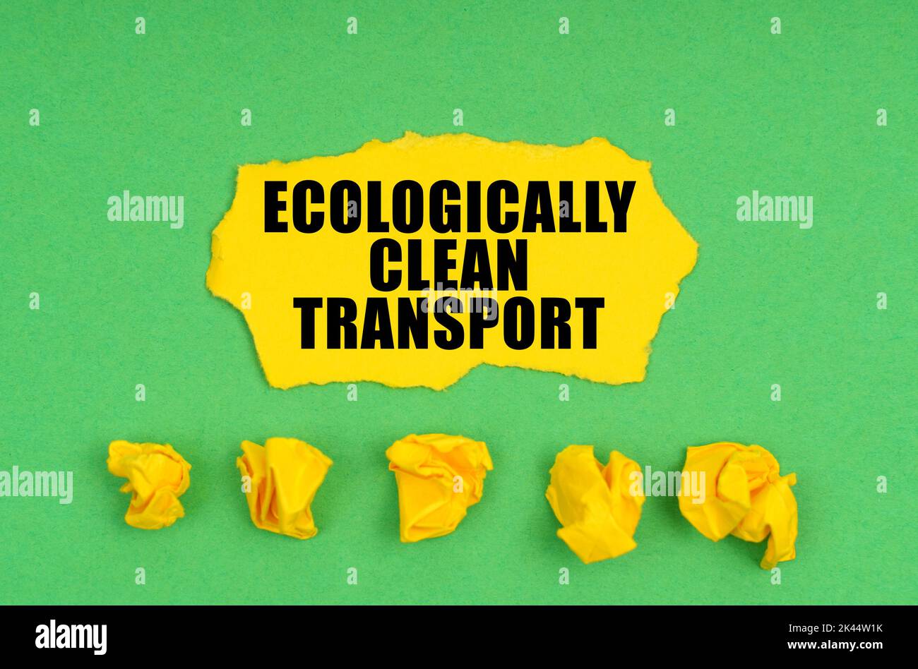 Ecology concept. On a green background, crumpled yellow paper and a ...