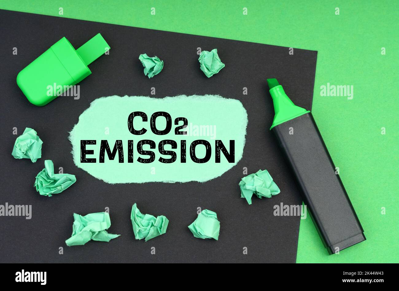 Ecology concept. On a green background, a marker, a black sheet and ...