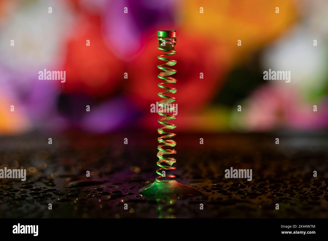 Copper spring holder closeup on the color background on wet surface ...