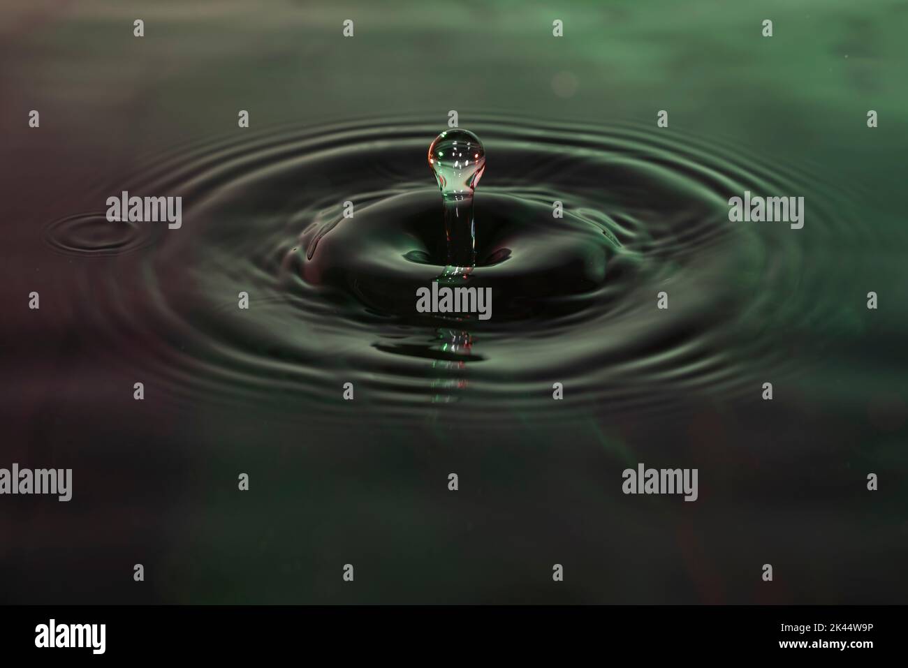 Green and red water dropping, water ripples in a pond. waves of ...