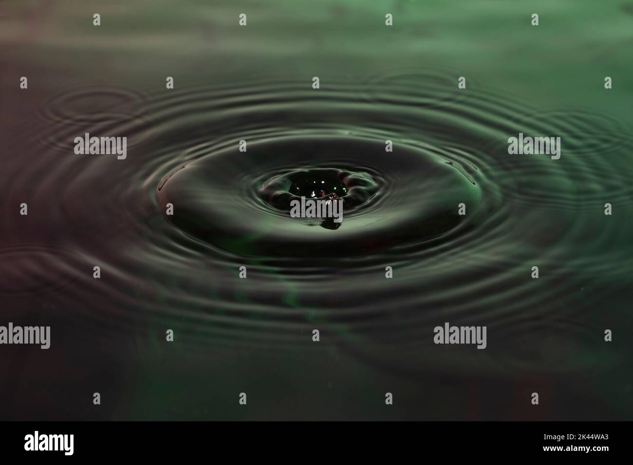 Green and red water dropping, water ripples in a pond. waves of ...