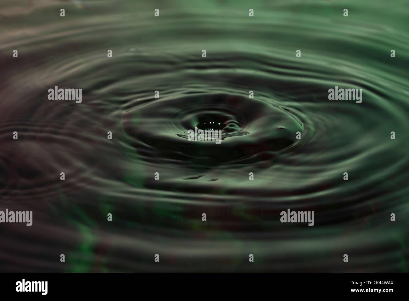 Green and red water dropping, water ripples in a pond. waves of ...