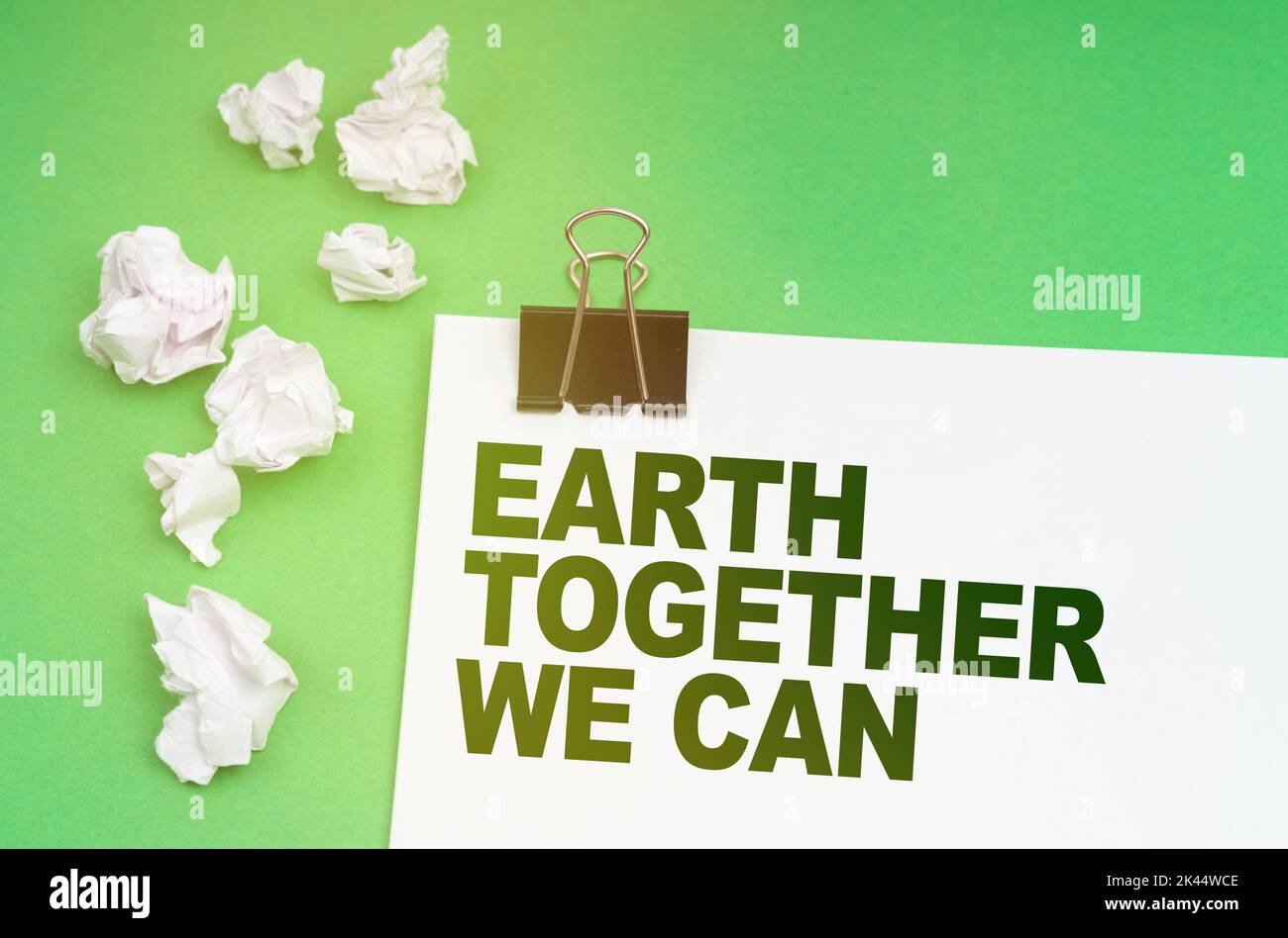 Ecology concept. On a green background, crumpled paper and a sheet with ...