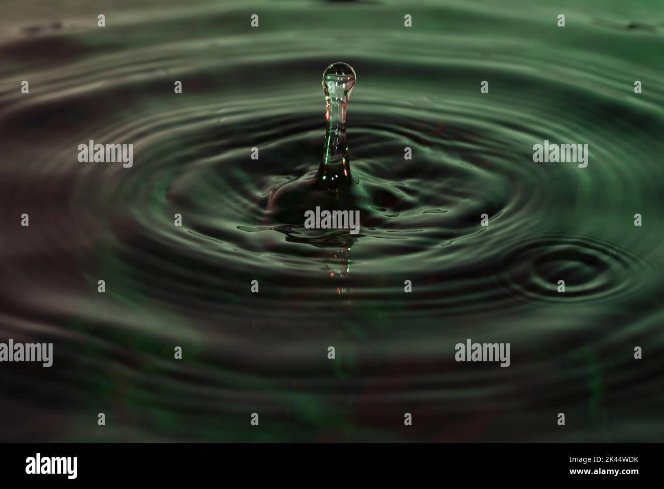 Green and red water dropping, water ripples in a pond. waves of ...