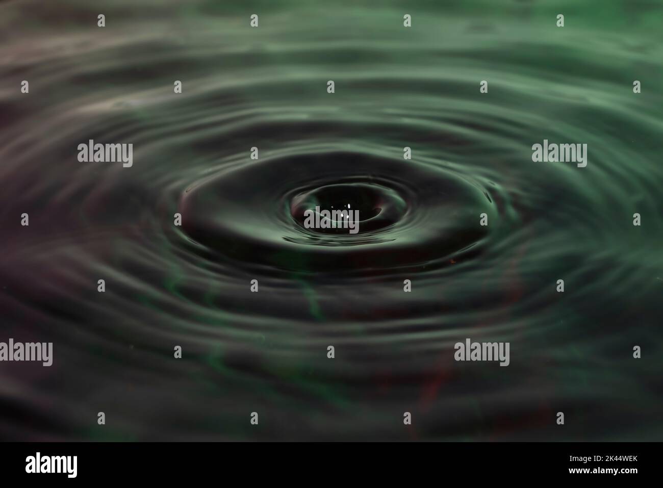 Green and red water dropping, water ripples in a pond. waves of ...