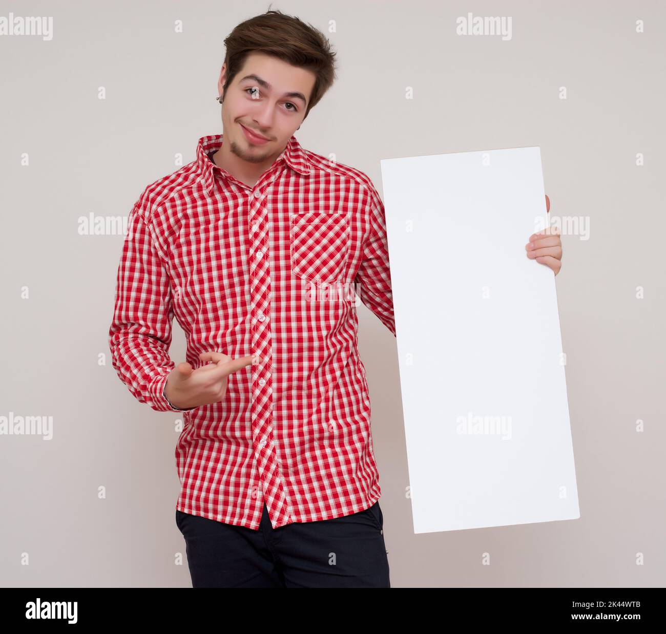 Happy smiling young business man showing blank signboard, isolated over ...